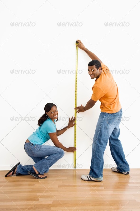 Couple measuring wall - Stock Image - Everypixel
